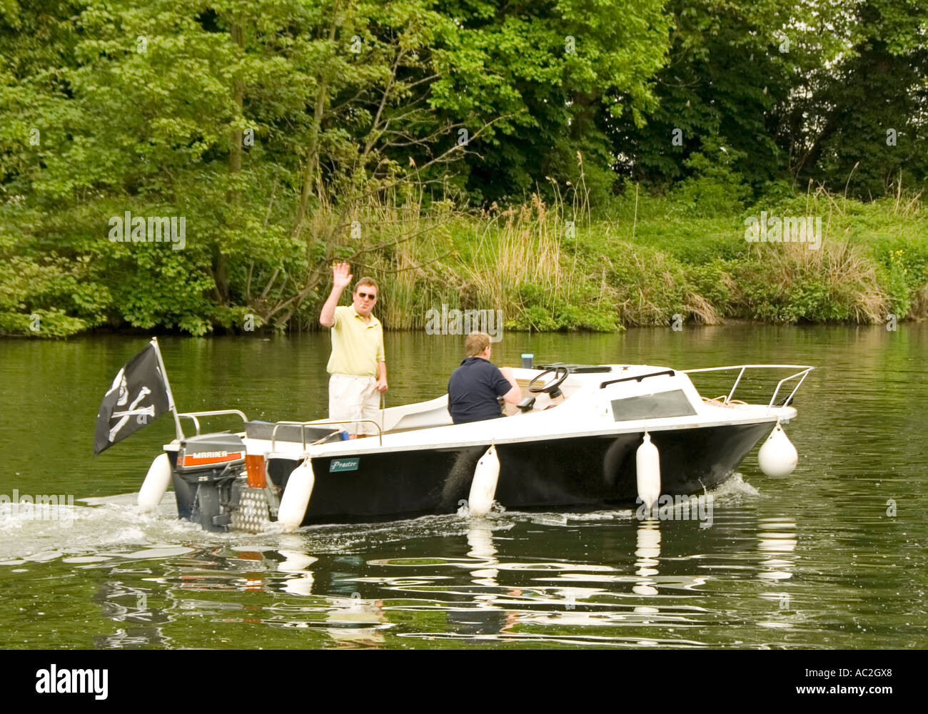 Man waving his hand from a motorboat flying the pirates flag Stock ...