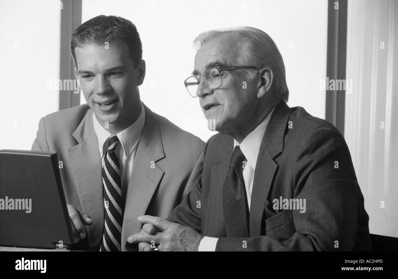 Older businessman learning computer skills from younger man Stock Photo ...