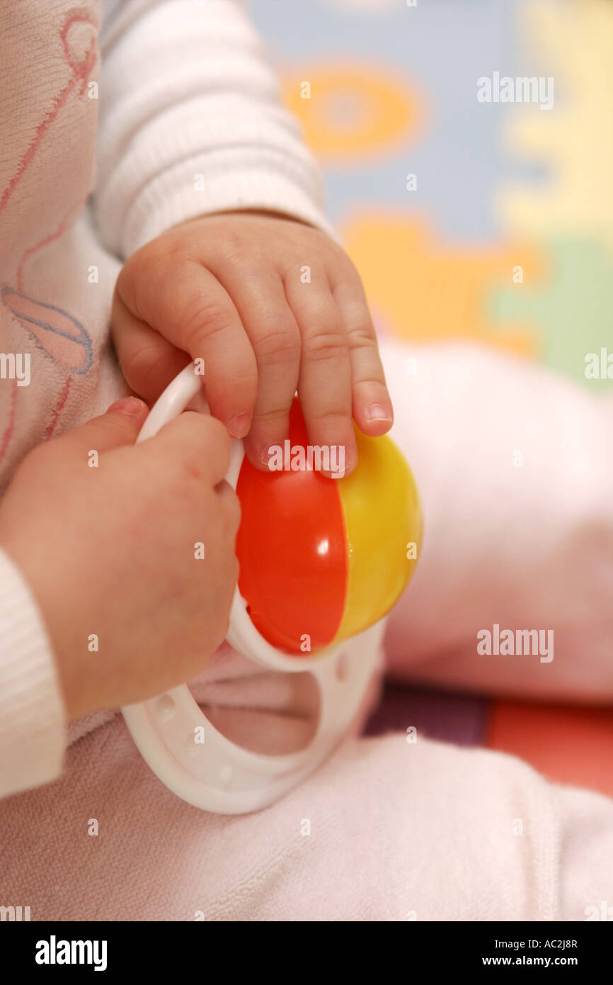 Baby hand holding rattle toy detail hi-res stock photography and images ...