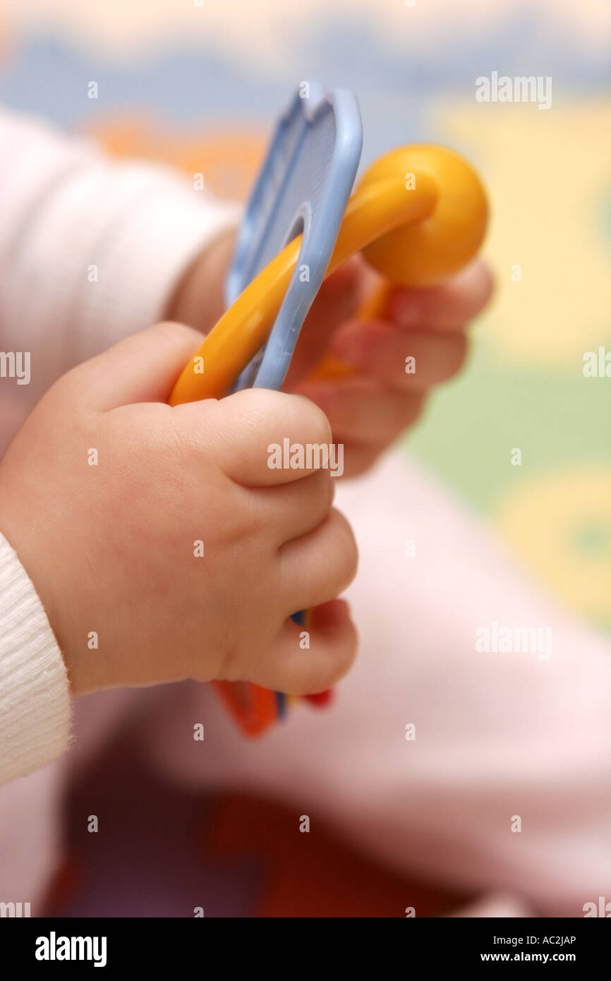 Baby hand holding rattle toy detail hi-res stock photography and images ...