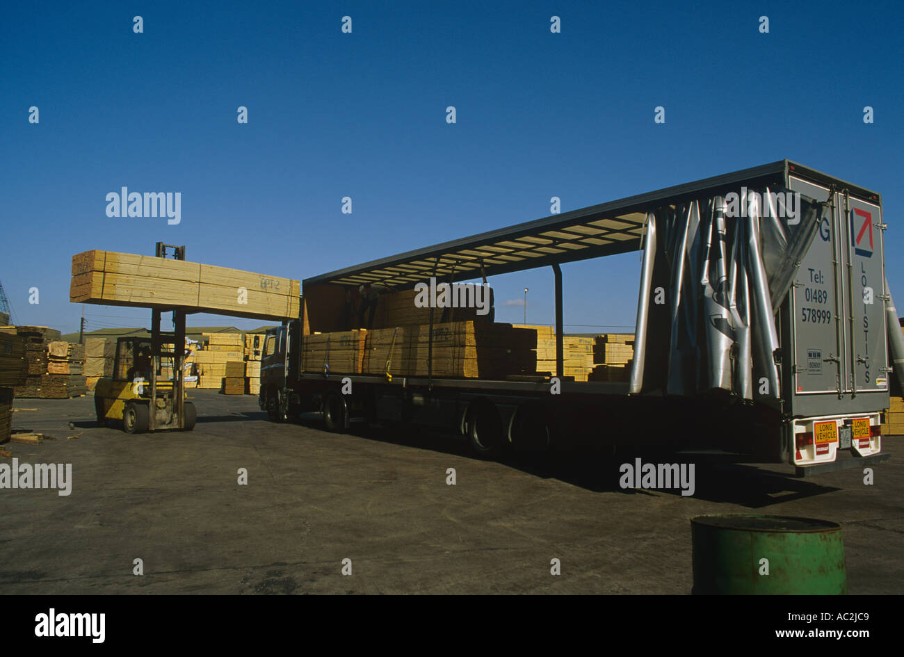 Cut timber from Scandinavia is landed stored and loaded onto trucks at ...