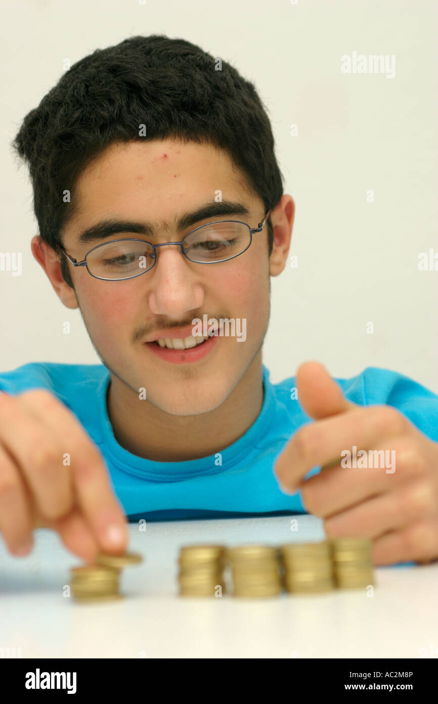 portrait of a young boy happily counting his saved pocket money Stock ...