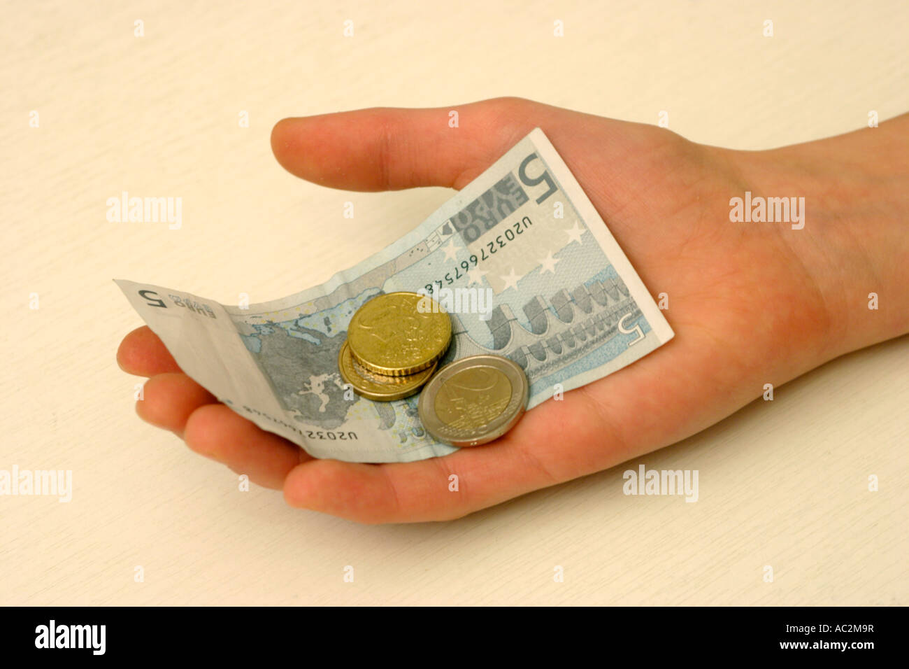 a young boy´s hand holding money Stock Photo - Alamy