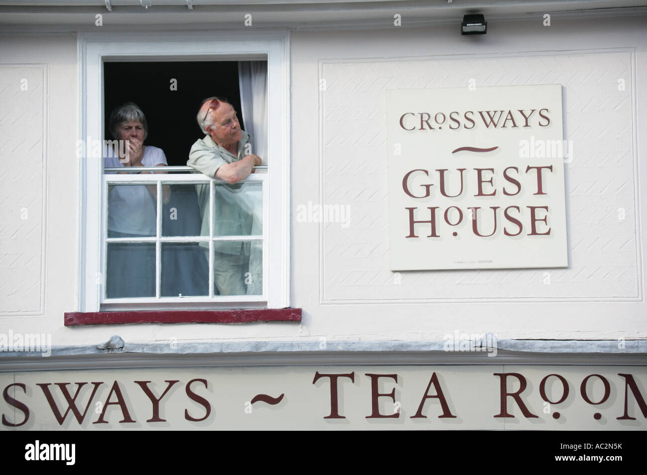 Guests at the window of their bedroom at a guest house, Thaxted, Essex ...