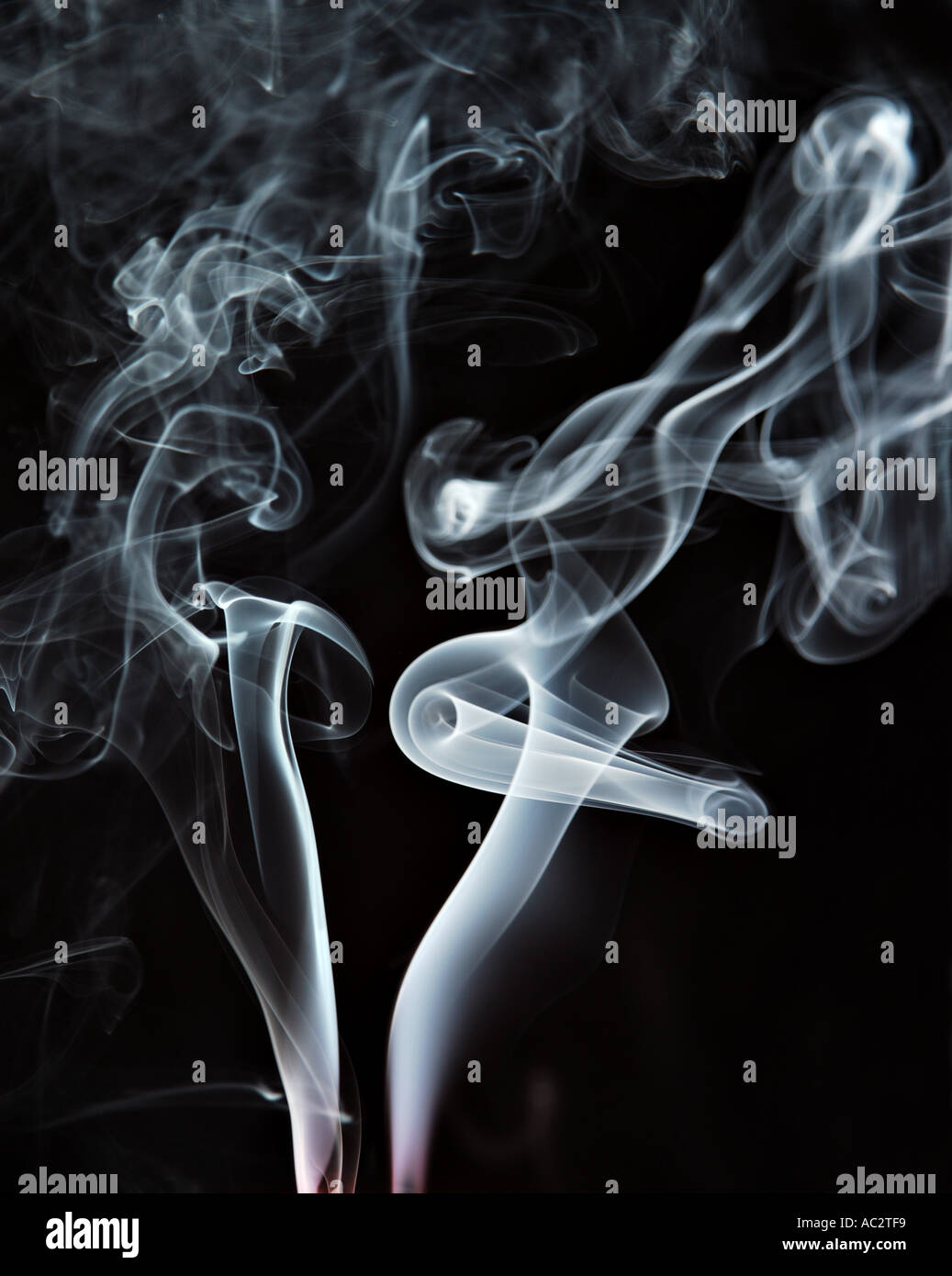 Curling smoke from two extinguished candles on black background Stock ...