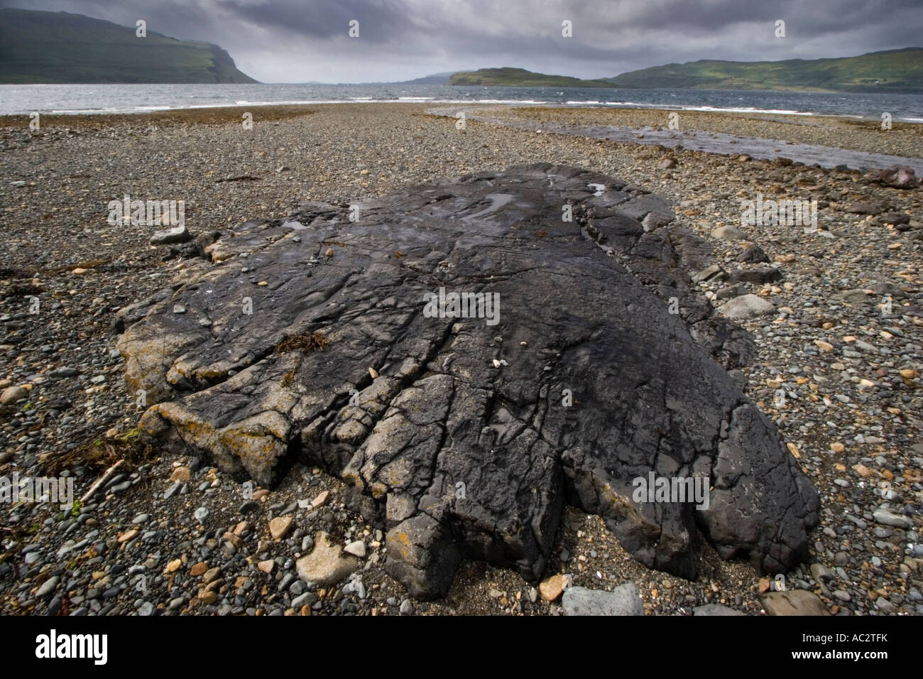 Flat boulder in foreground on a beach on the west coast of Mull ...