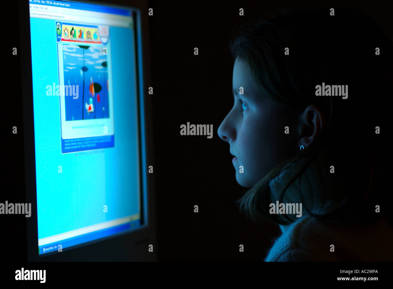 Young girl playing a video game on a computer in the dark Stock Photo ...