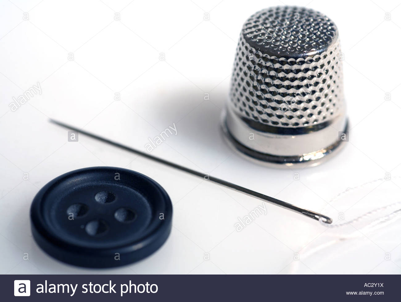 Thimble button needle and thread Stock Photo - Alamy