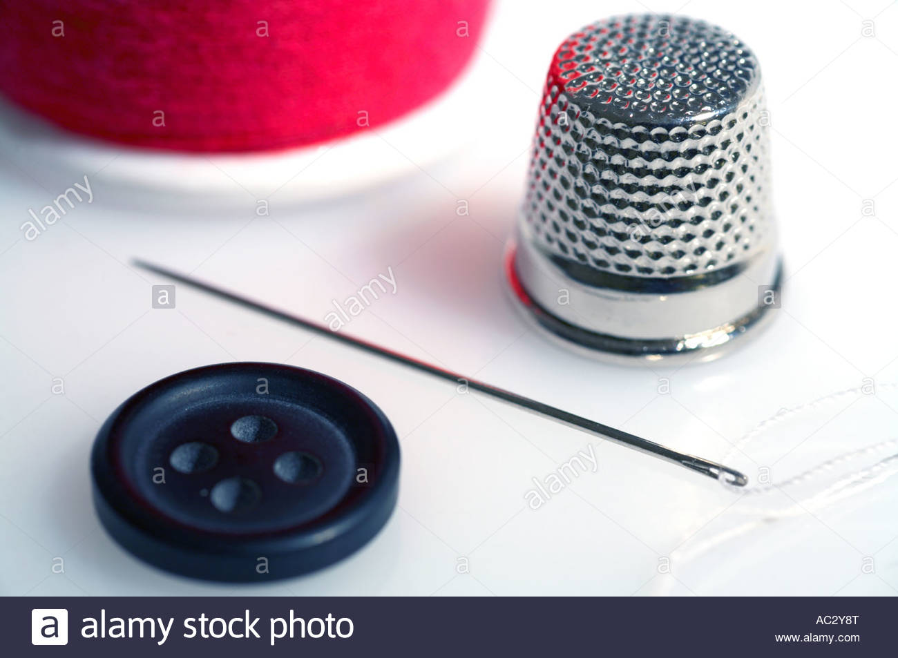 Thimble button cotton reel needle and thread Stock Photo - Alamy