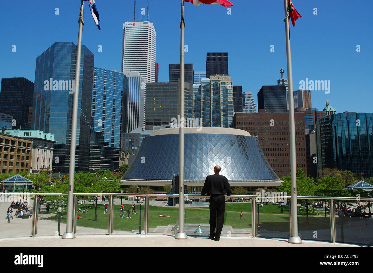 Man looking out over Metro Hall park and Toronto financial district ...