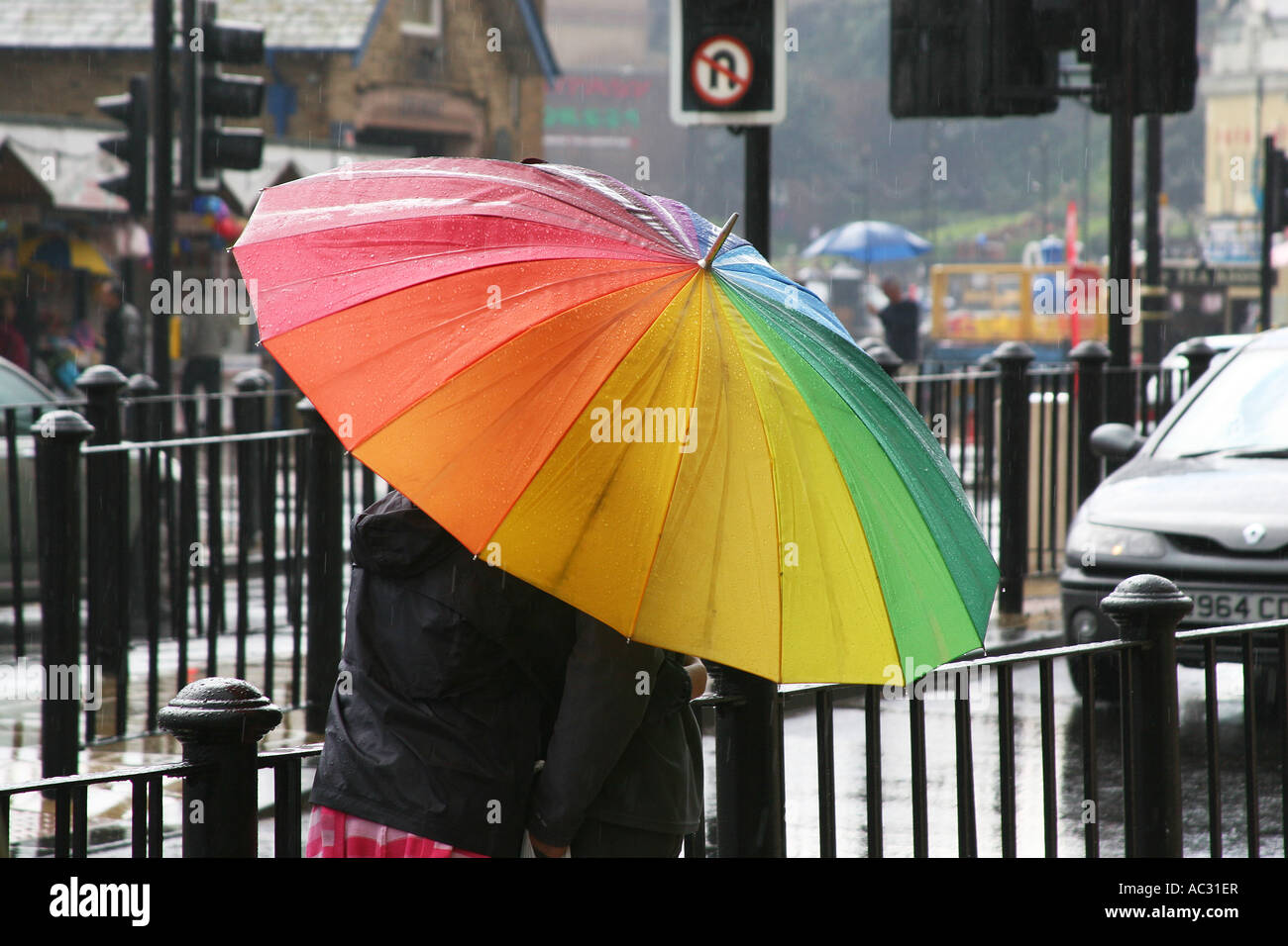 Multi coloured umbrella protecting people from heavy rain Stock Photo ...