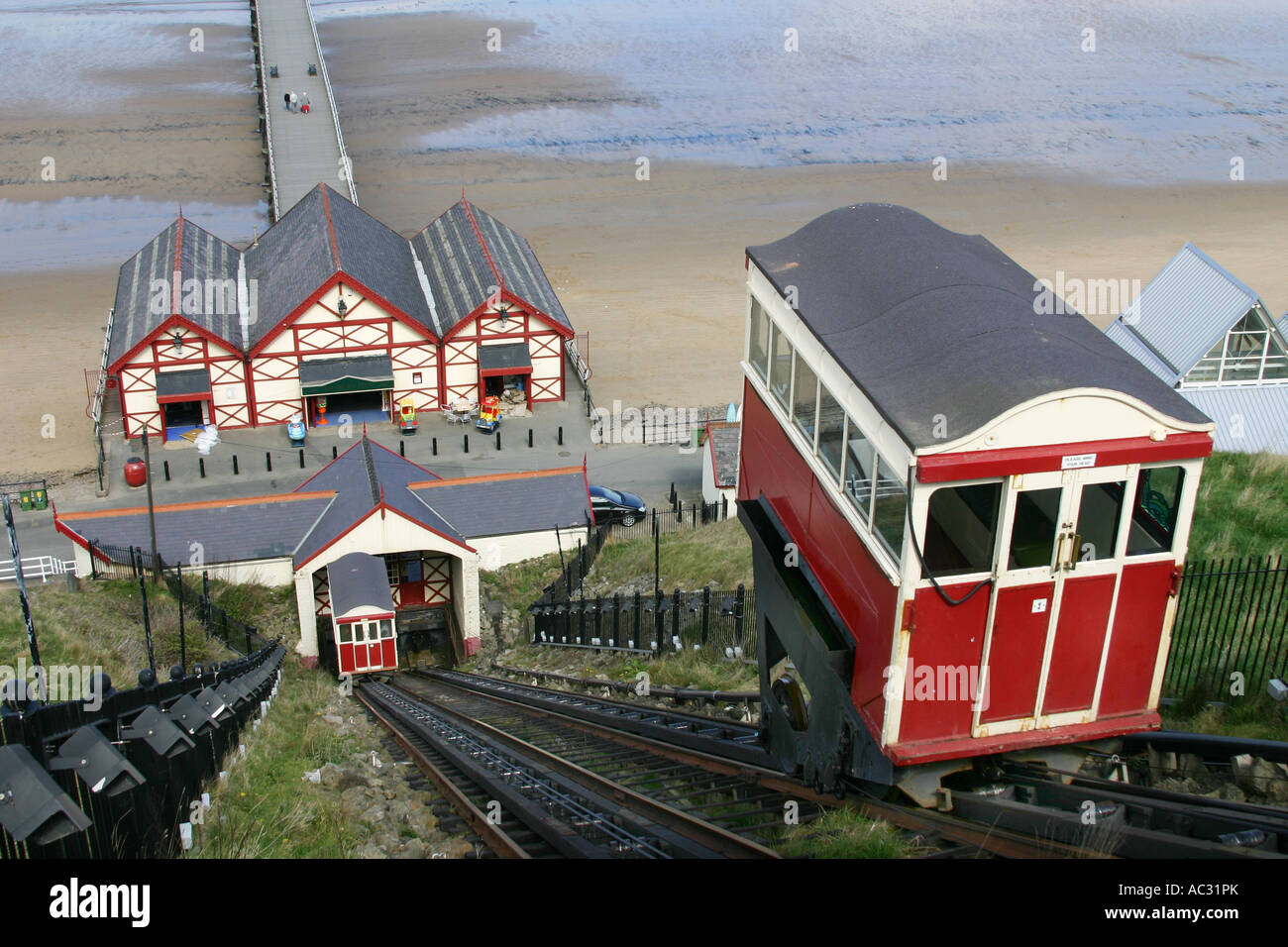 Saltburn pier and amusement arcade at low tide with cliff lift tram ...