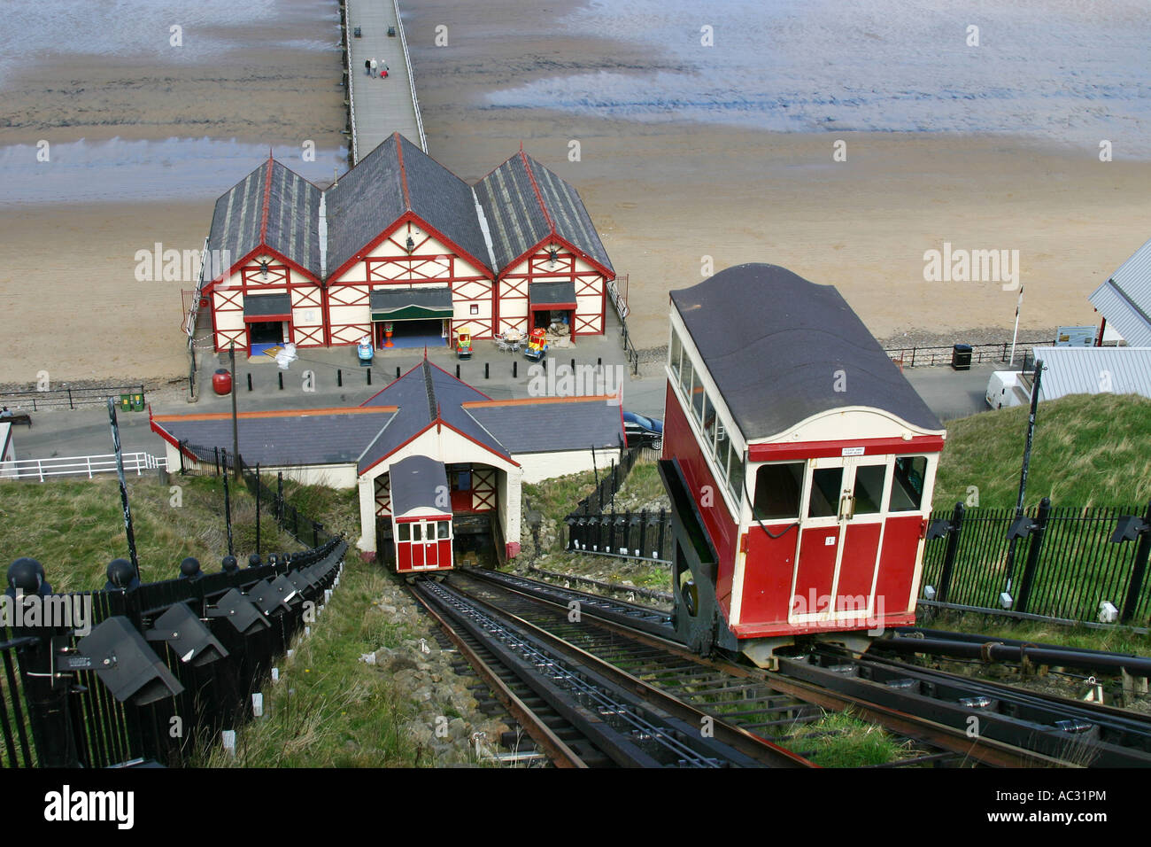 Saltburn pier and amusement arcade at low tide with cliff lift tram ...