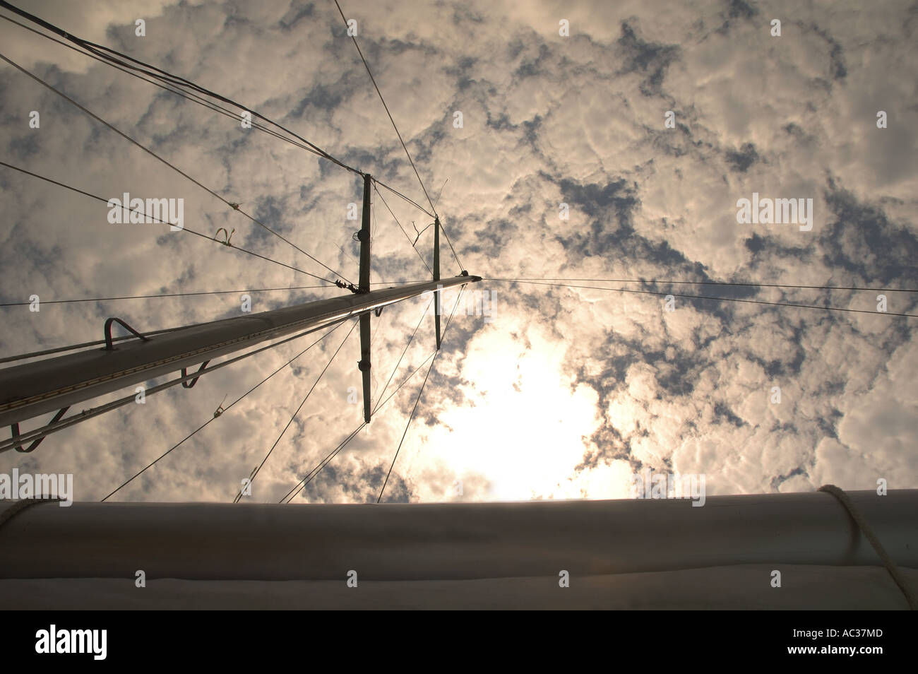 Clouds and sun surround the mast of a sailboat Stock Photo - Alamy