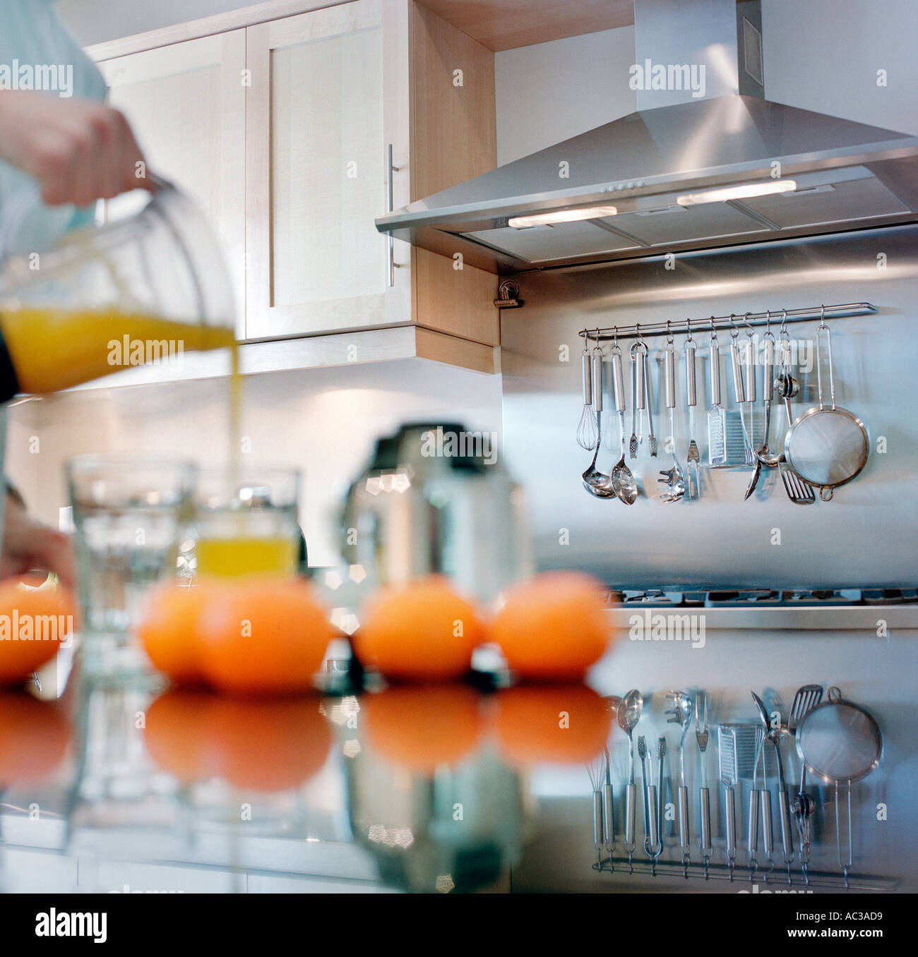 Pouring orange juice from a jug affluent kitchen London Stock Photo - Alamy
