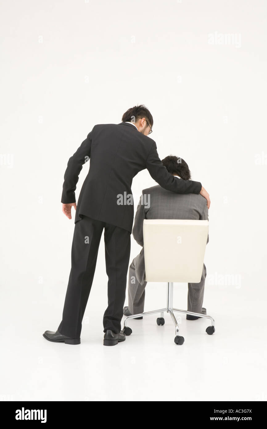 Businessman consoling his colleague Stock Photo - Alamy