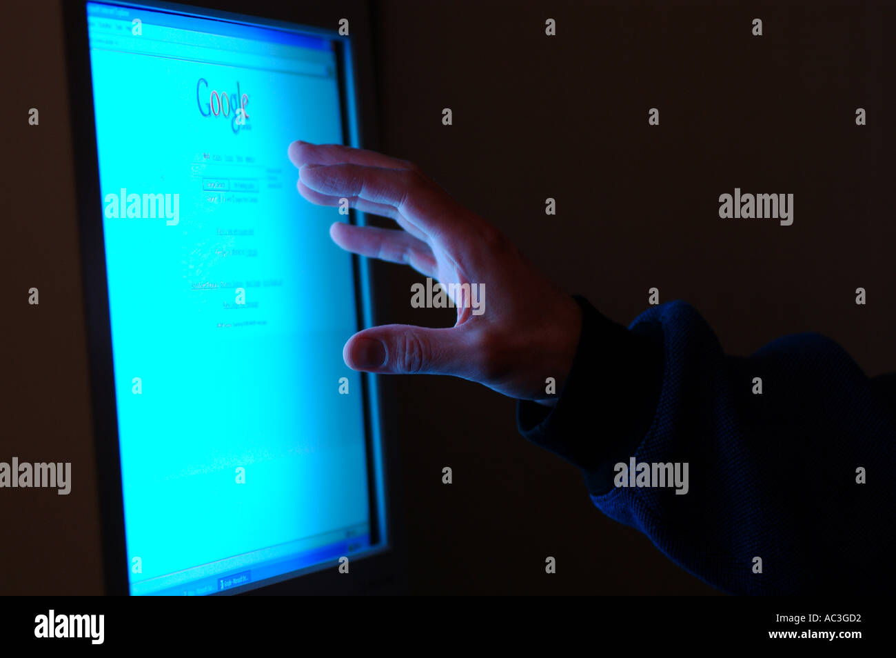 Hand reaching into a computer monitor in the dark Stock Photo - Alamy