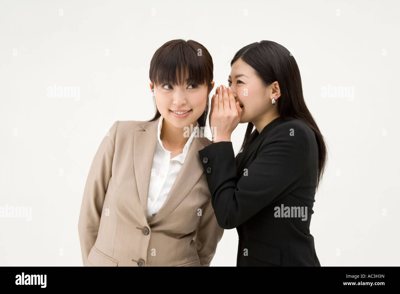 Businesswoman whispering to her colleague Stock Photo - Alamy