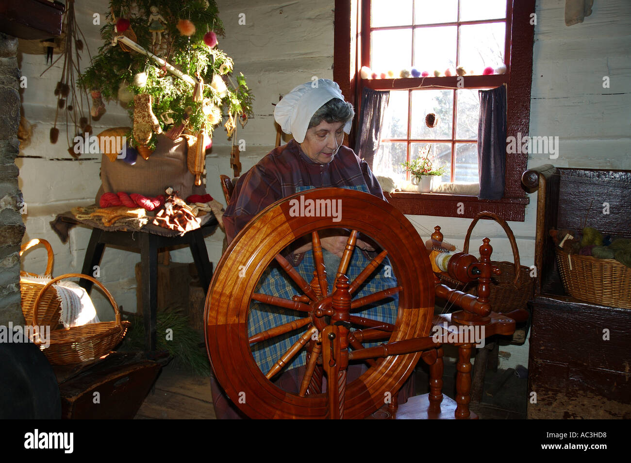 wool spinner in log cabin Stock Photo - Alamy