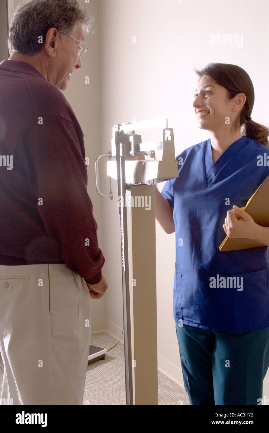 Portrait of nurse taking older patients weight Stock Photo - Alamy