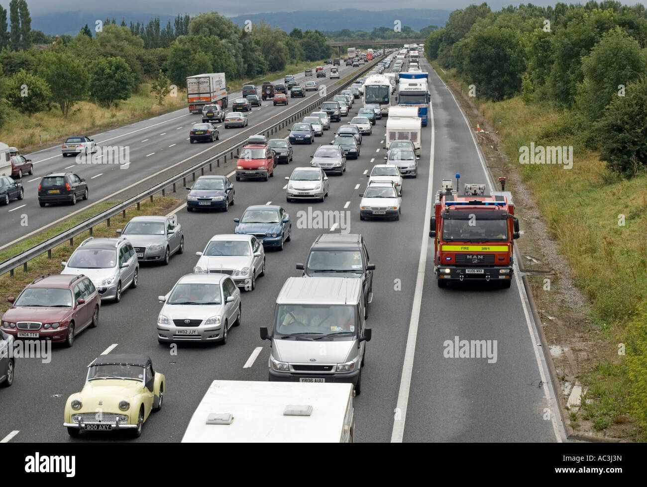 Fire engine on hard shoulder of M5 motorway alongside busy traffic ...