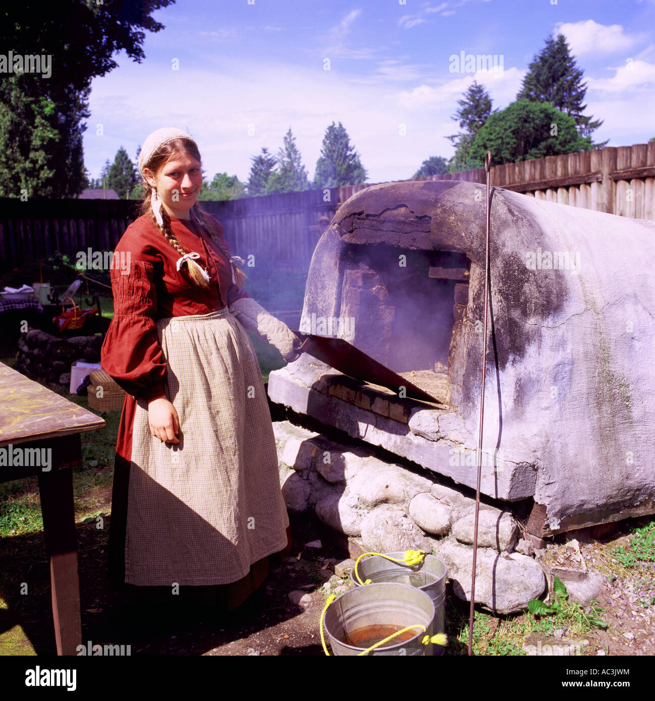 Woman Re-enactor baking Bread in Old Outdoor Bake Oven at Fort Langley ...