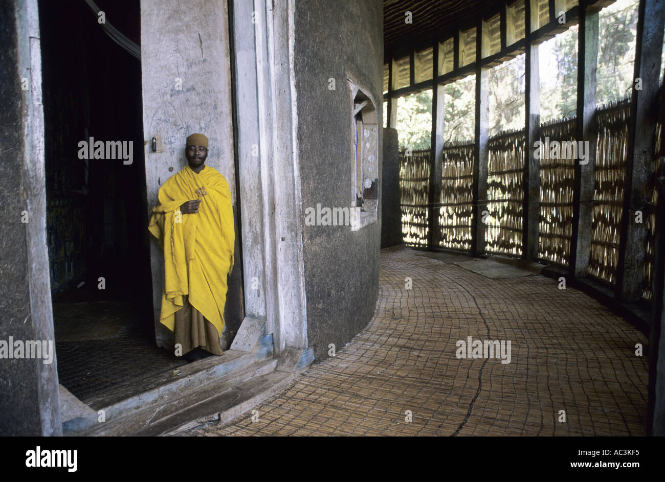 Yellow robed priest standing in the doorway of the Ura Kidane Meret ...