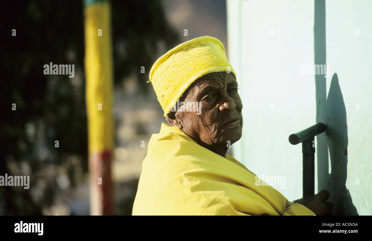 Yellow robed priest kissing the wall of the 19th century Adigrat ...