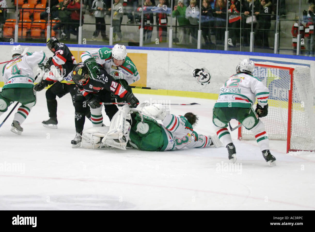 The goalie gets a hit with a stick and his helmet is flying away in a ...