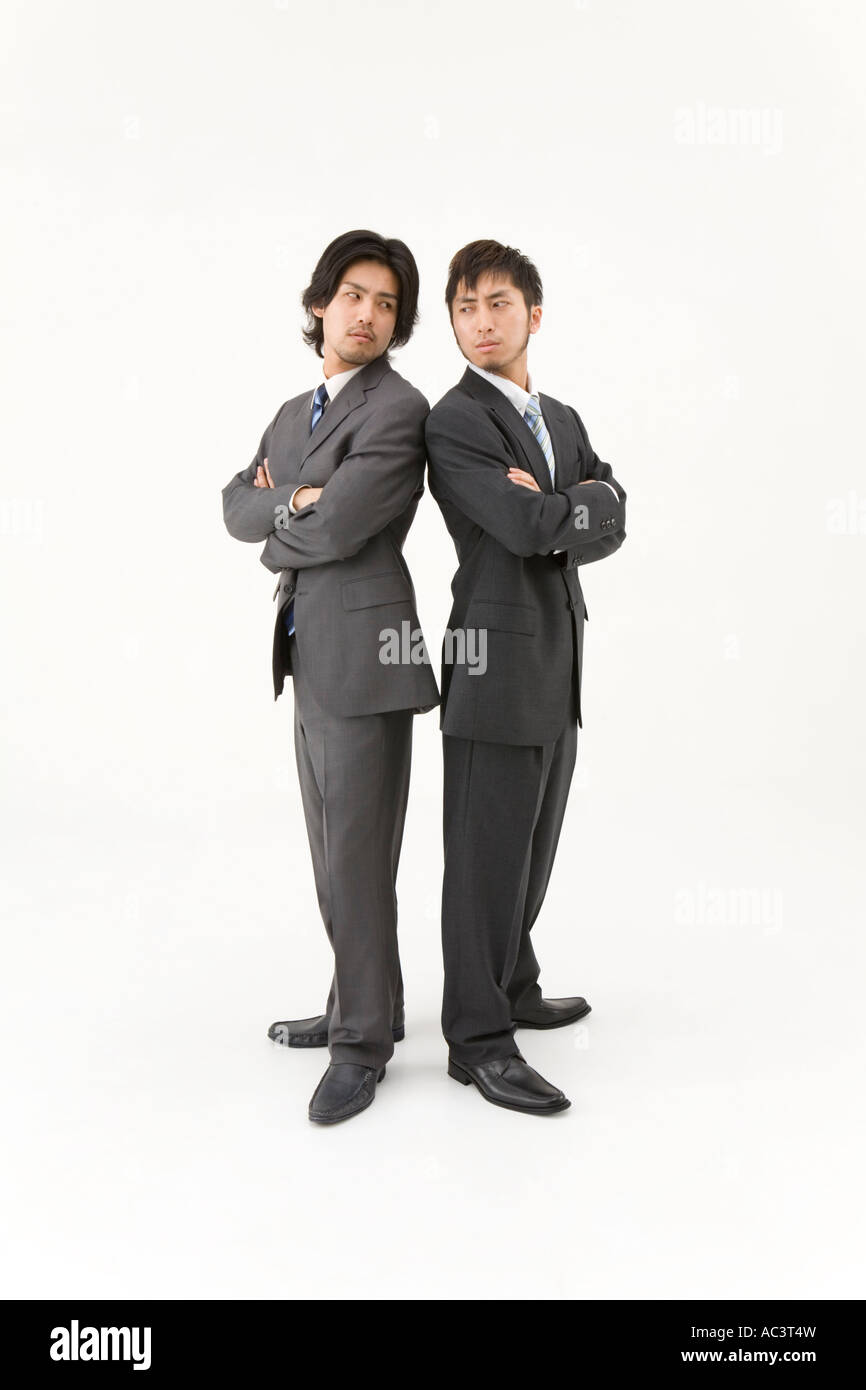 Two businessmen standing back to back Stock Photo - Alamy