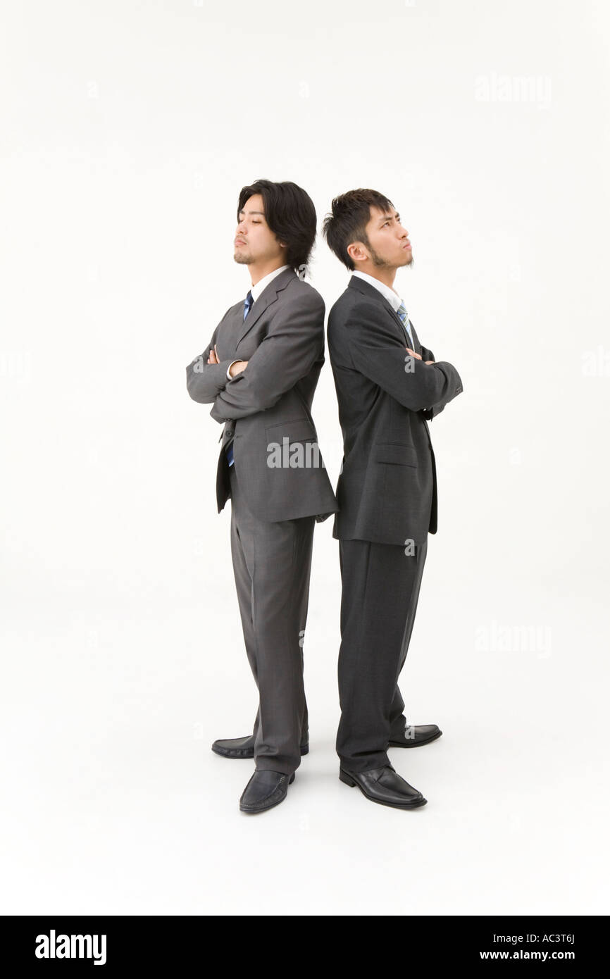 Two businessmen standing back to back Stock Photo - Alamy