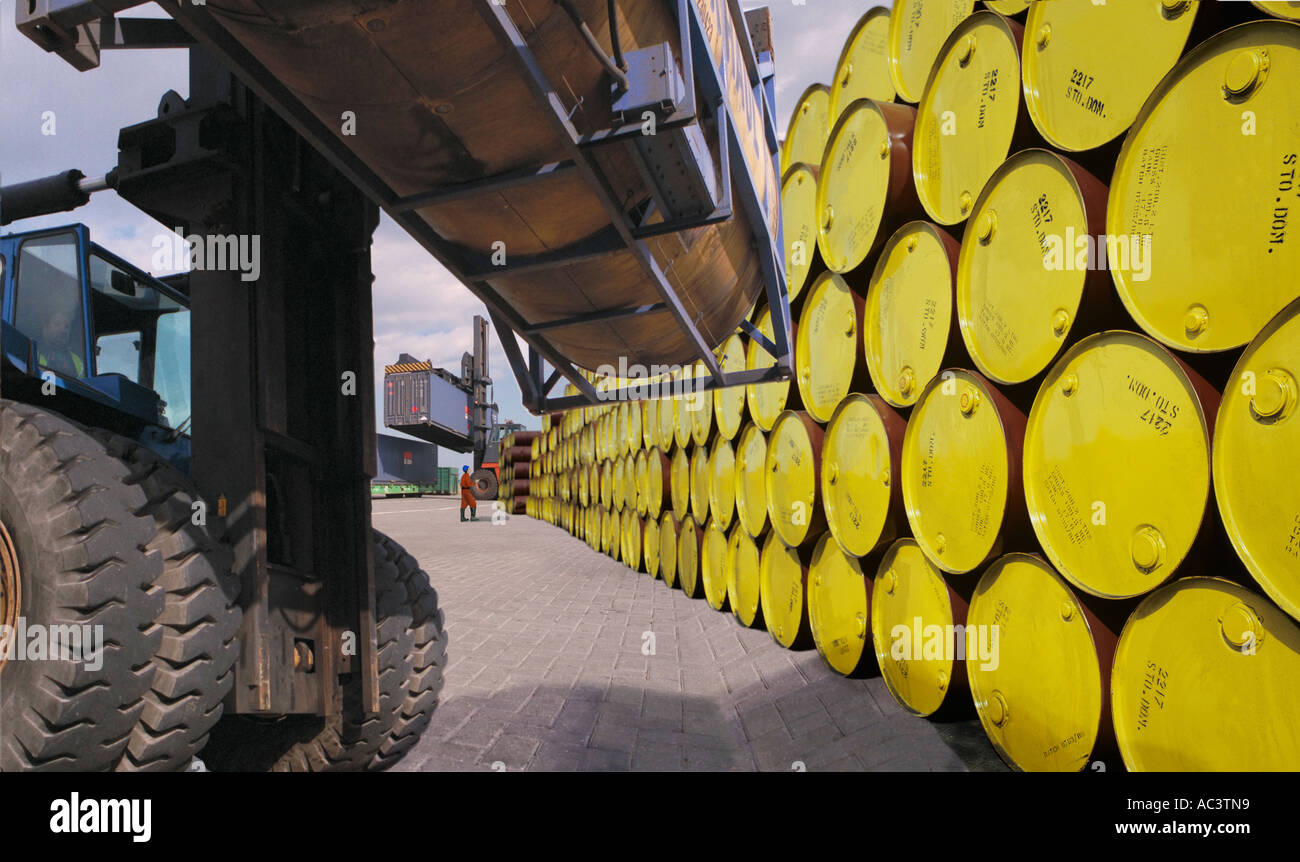 Loading and offloading oil drums at port dockside Stock Photo - Alamy