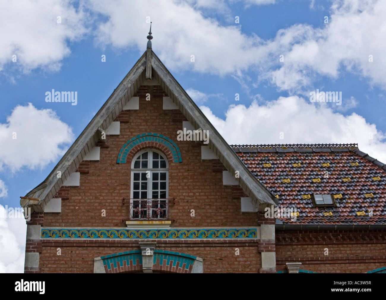 French steep pitched roof and blue brick arched window and decorative ...