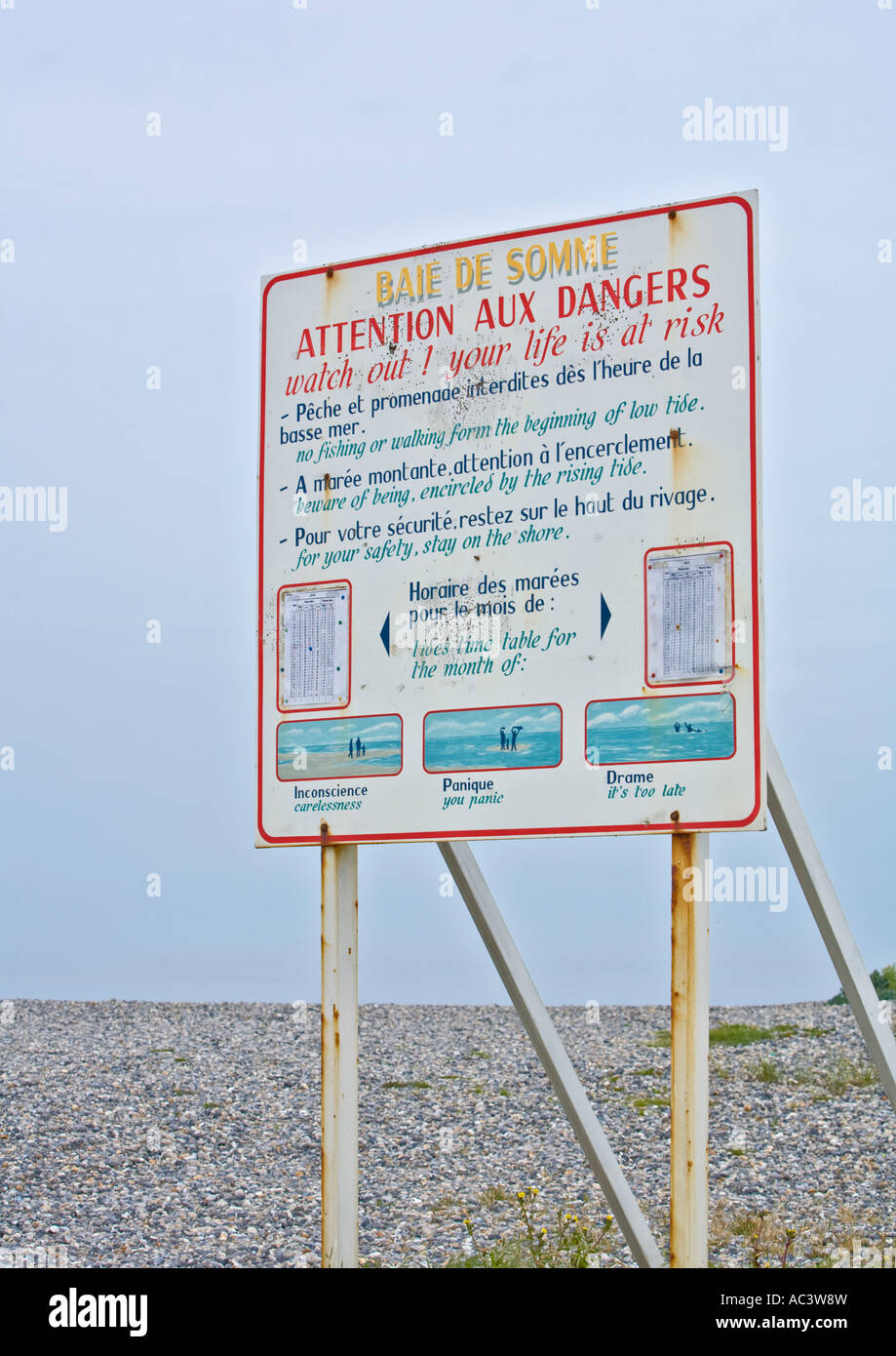 Close up of bilingual french and english danger sign on shingle quarry ...