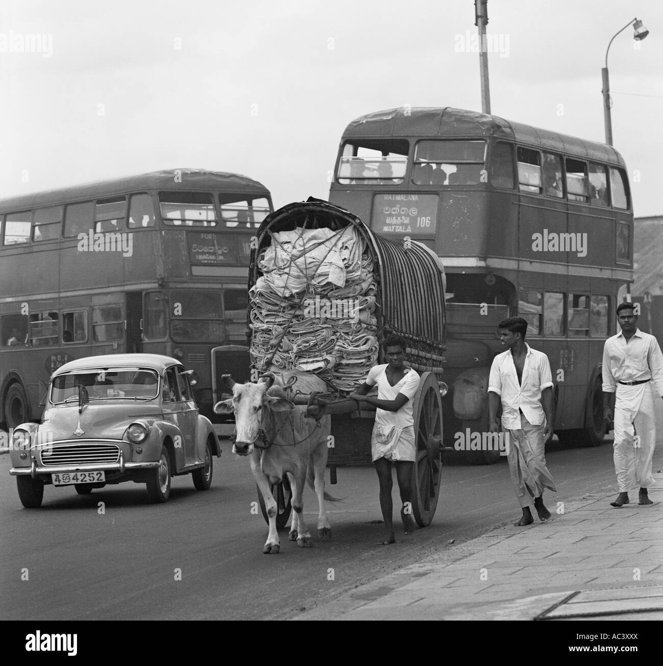 Old street scene of ox cart old London buses and Morris Minor in ...