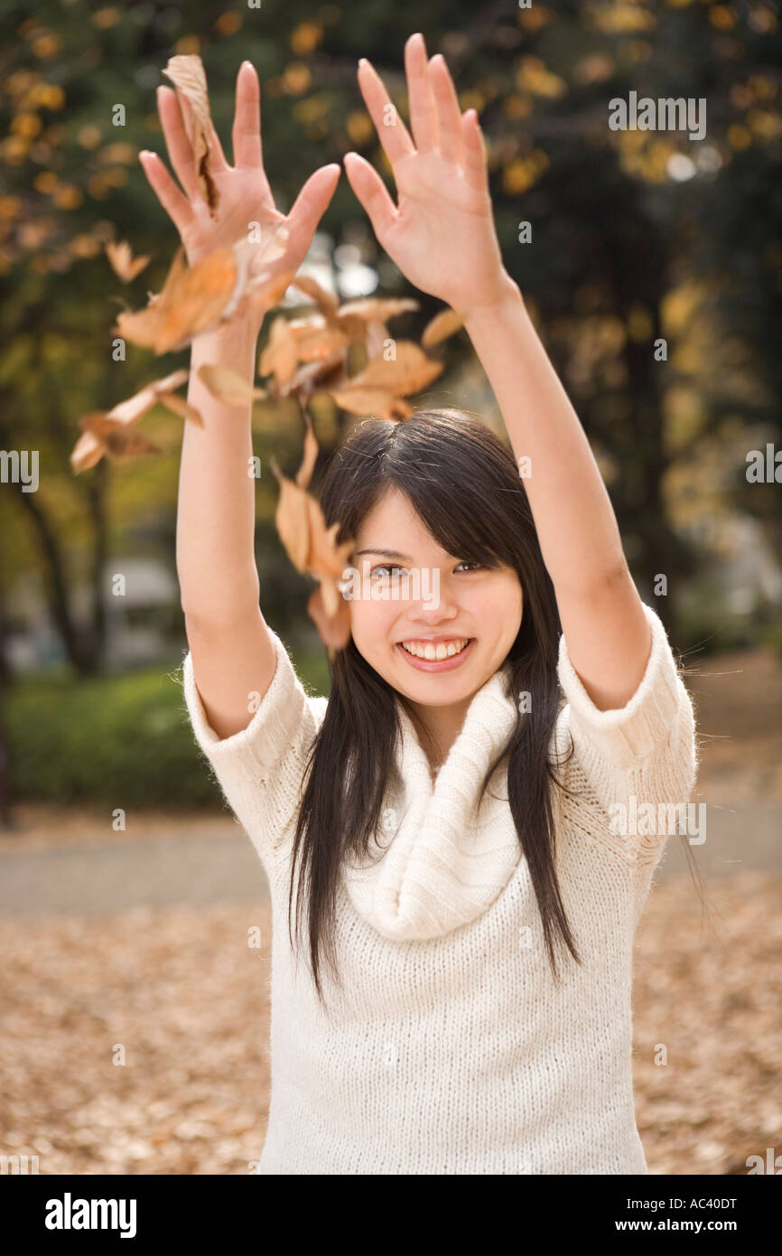 Young woman throwing fallen leaves Stock Photo - Alamy