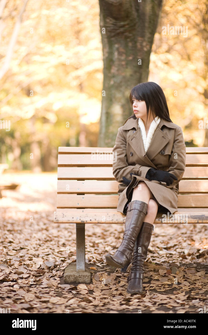 Young woman sitting on bench Stock Photo - Alamy