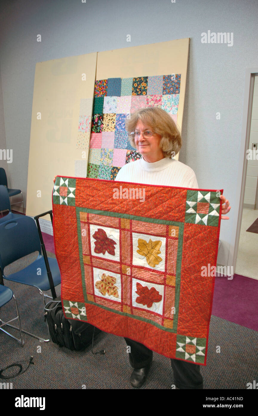 Women working in Quilting Class with needles and laptop computers to ...