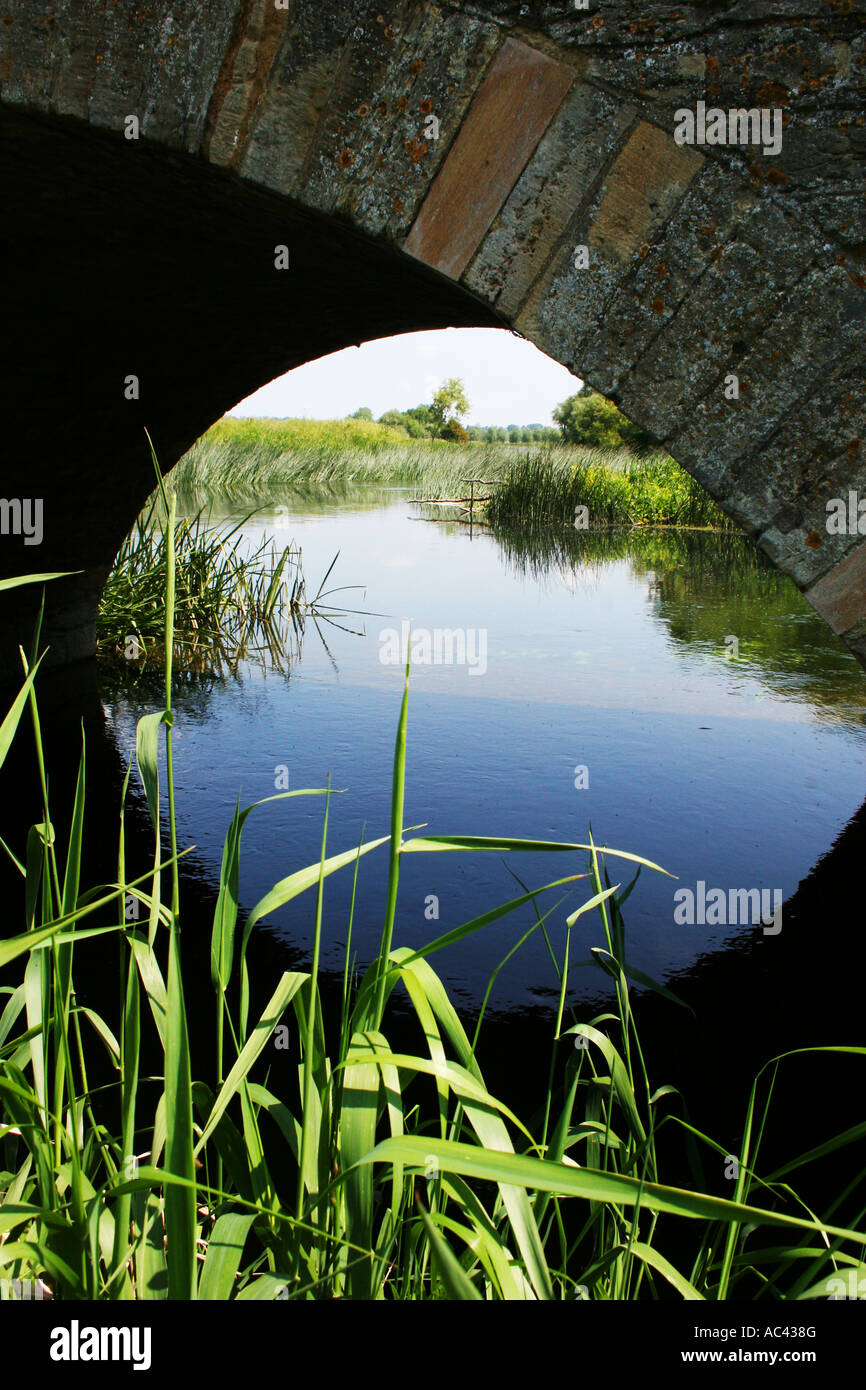 Quintessential England. Reflection and river through stone bridge arch ...