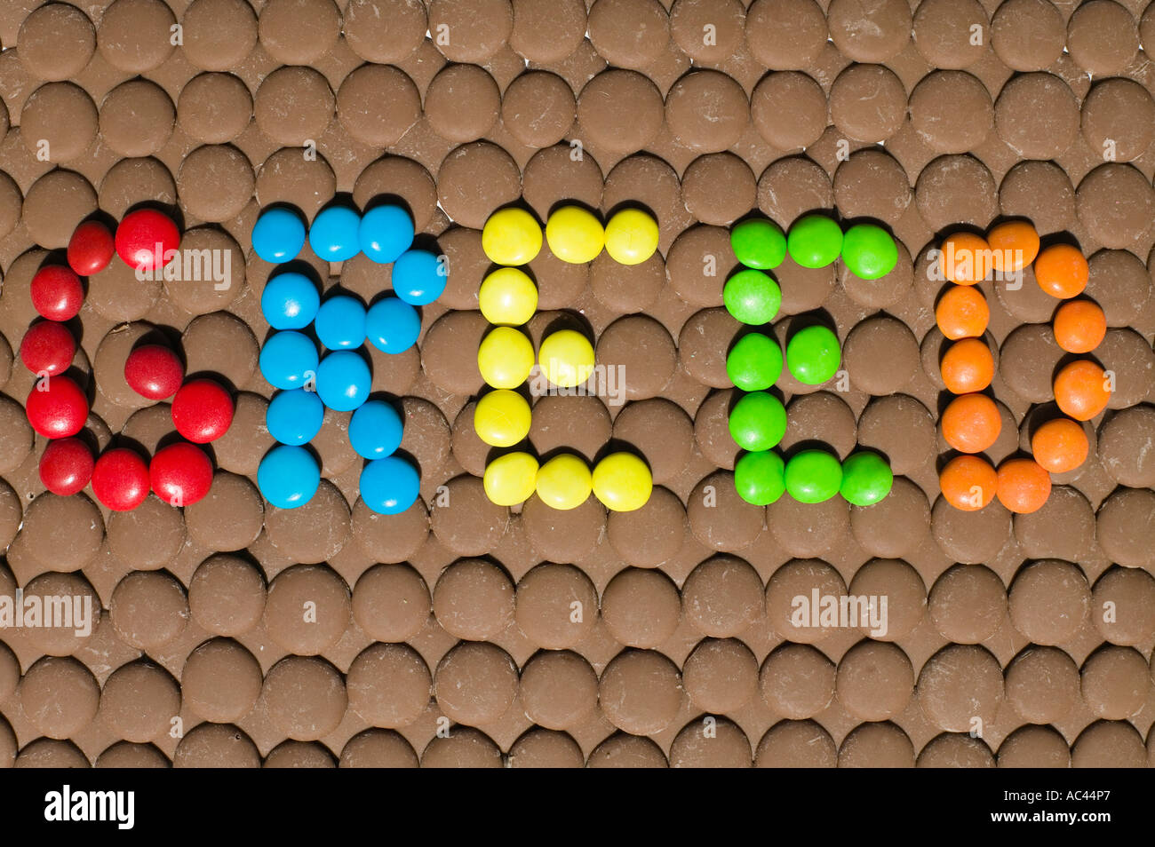 sweets and chocolate used to spell out the word greed Stock Photo - Alamy