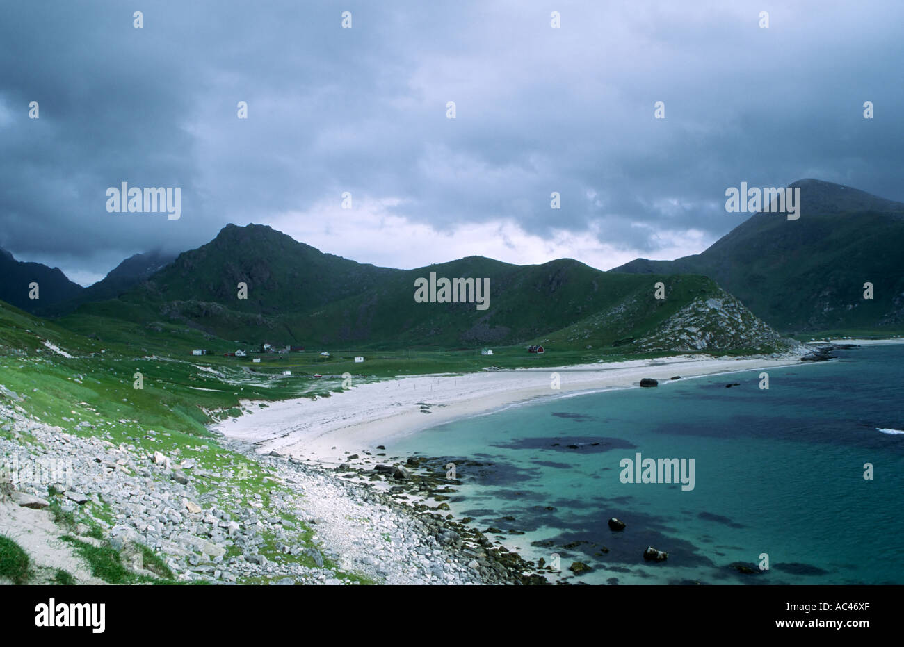 Clear blue water and white sand at a bay on a fjord in Northern Norway ...