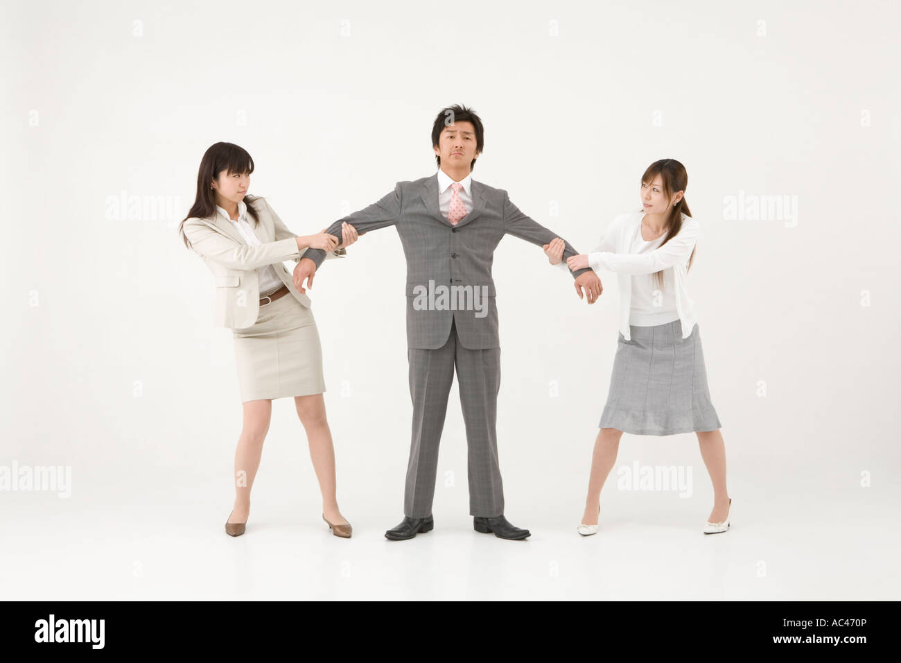 Two businesswomen fighting over man Stock Photo - Alamy