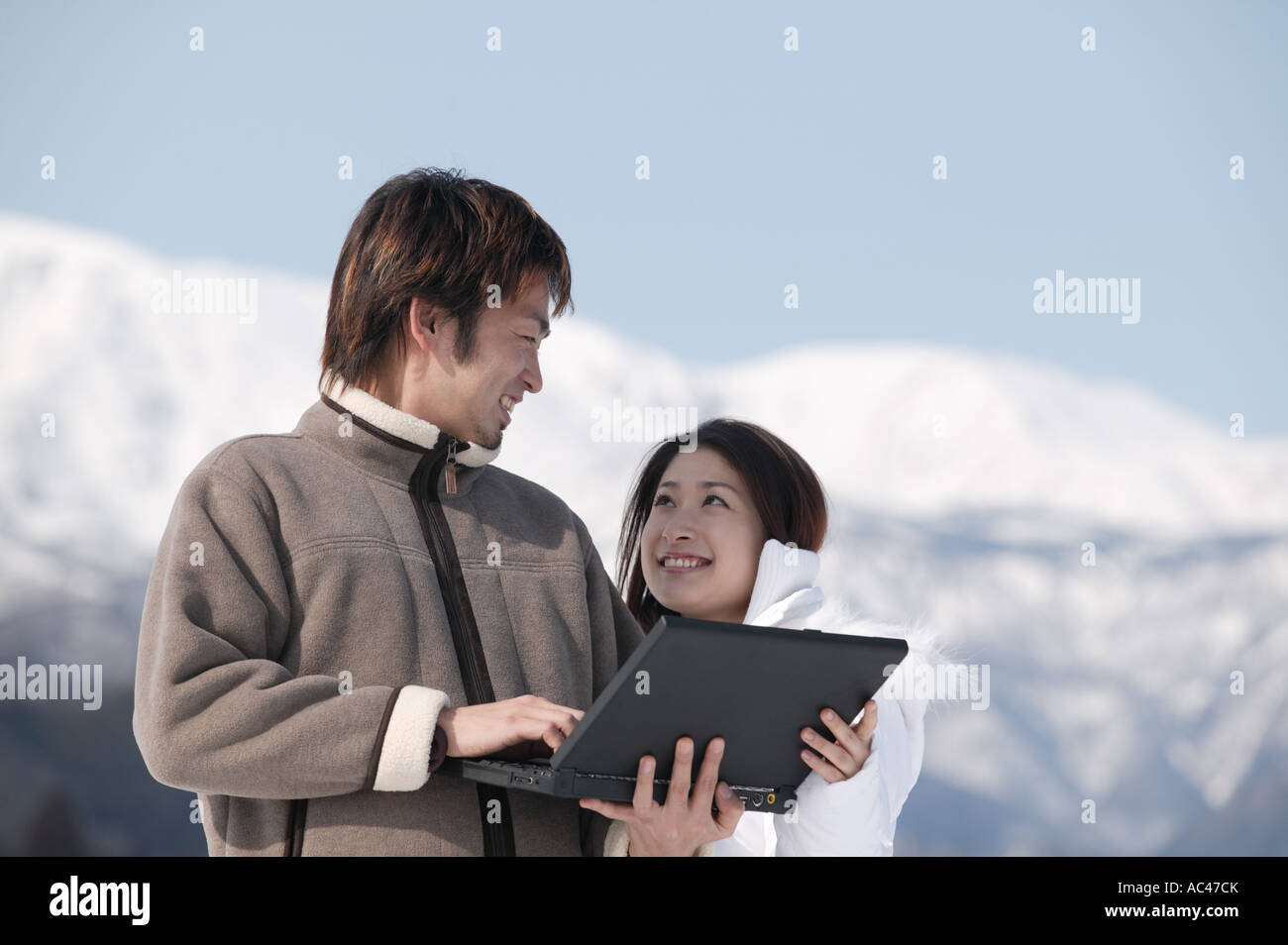 Young couple using computer outside Stock Photo - Alamy