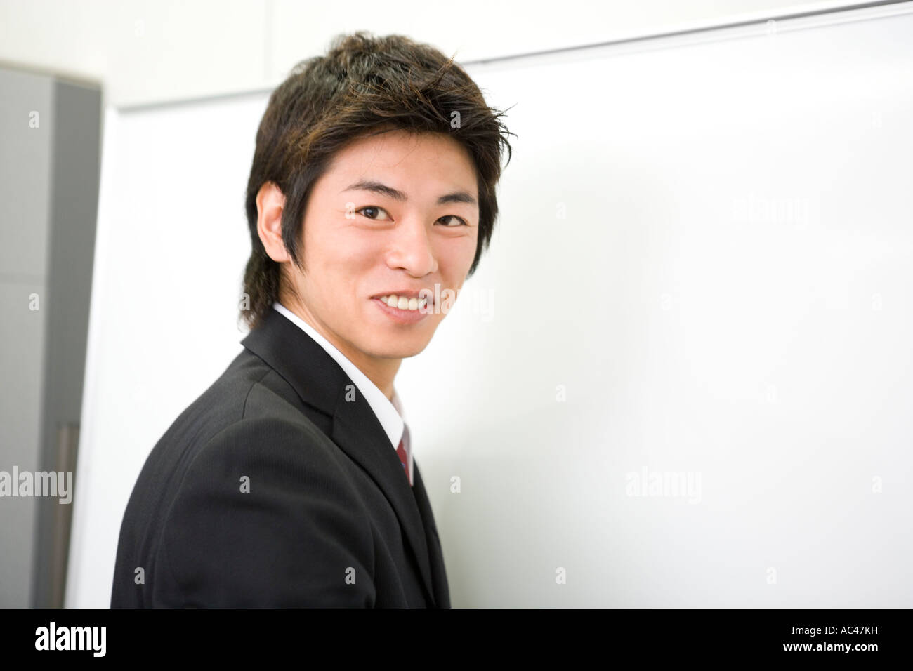 Young businessman smiling Stock Photo - Alamy