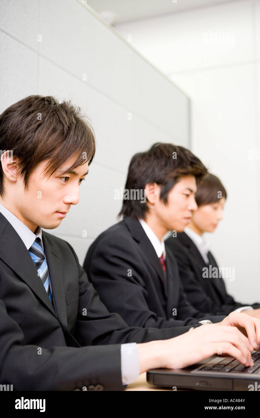 Three young business people using computers Stock Photo - Alamy