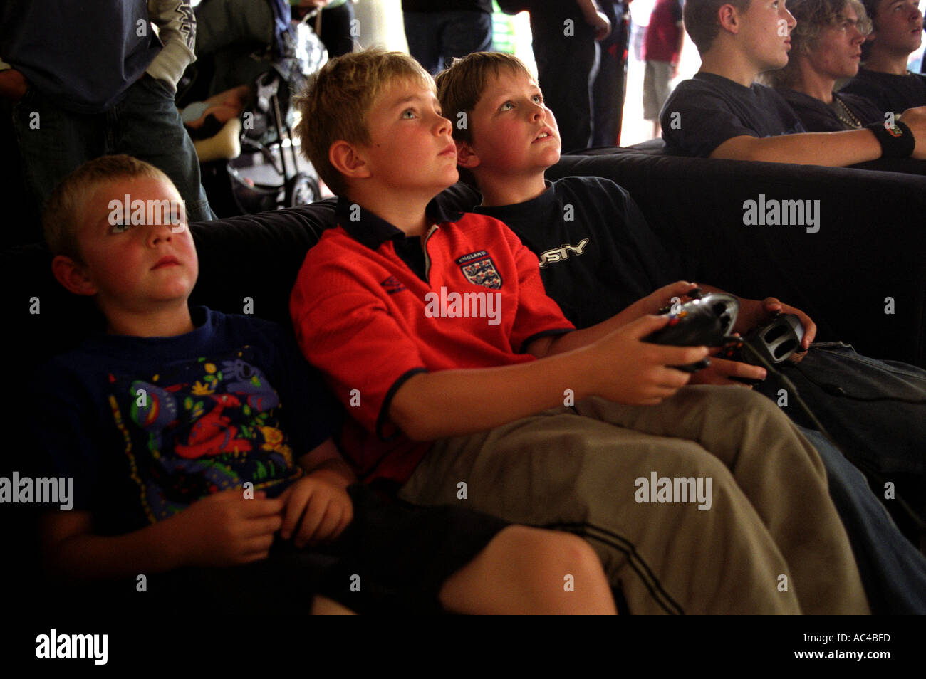 group of young boys concentrated playing on games machine at an urban ...
