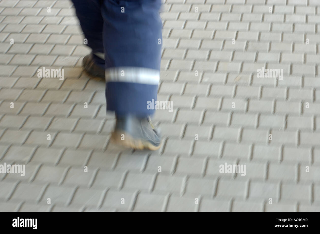 feet of a worker walking on the pavement. blurred Stock Photo - Alamy