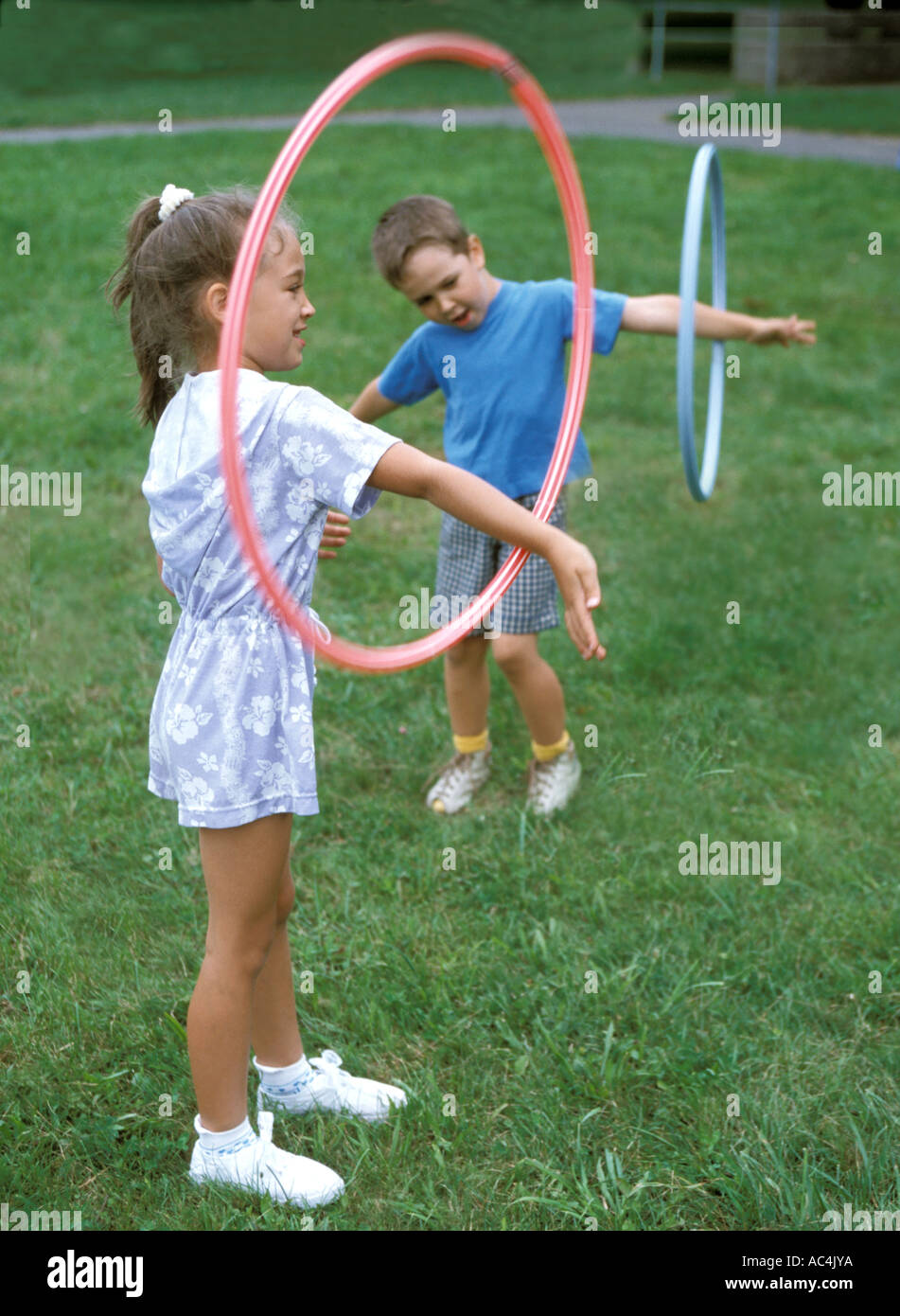boy and girl spinning hula hop circles Stock Photo - Alamy