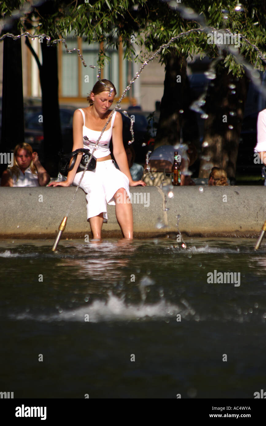 Girl cooling her feet in a fountain Stock Photo - Alamy
