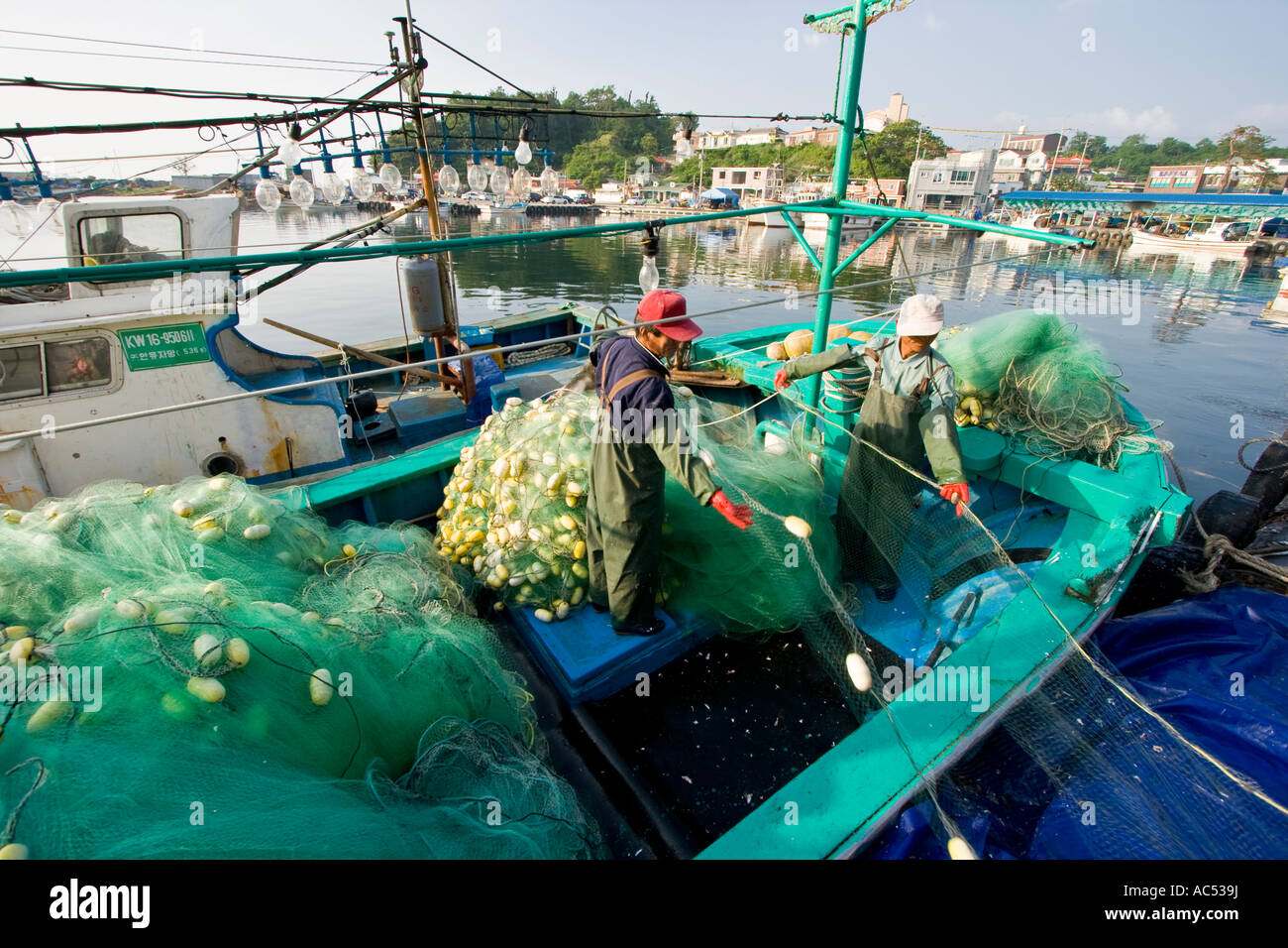 Korean Fisherman Pulling Nets into Fishing Boat before Heading out ...